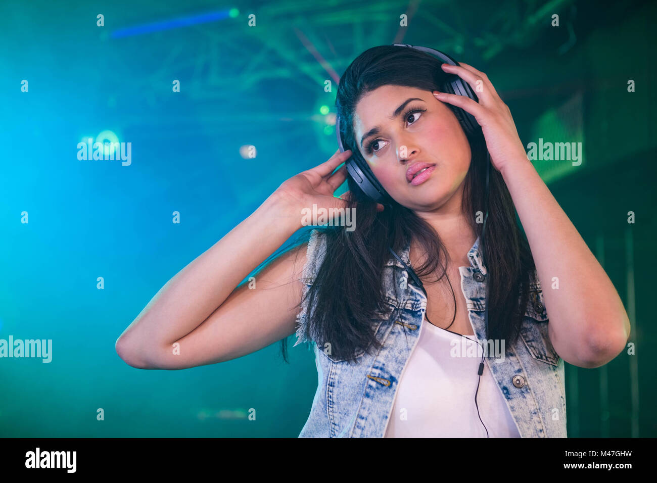 Pretty female DJ listening music on headphone Stock Photo - Alamy