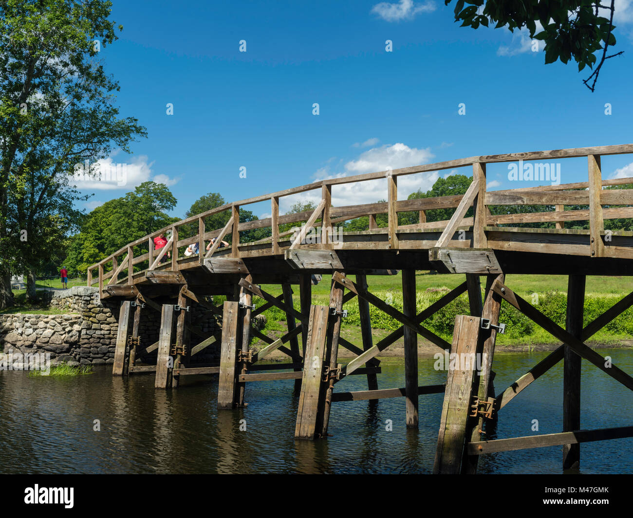 People walk across the Old North Bridge over the Concord River while ...