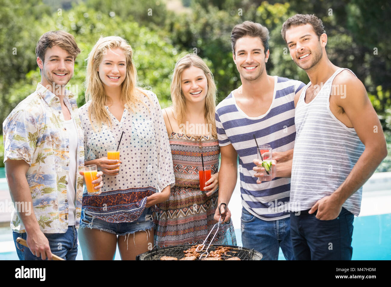 Group of friends preparing barbecue near pool Stock Photo - Alamy