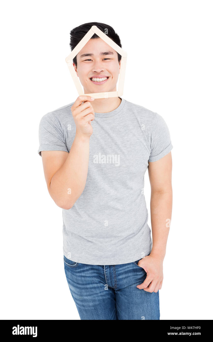 Young man holding house shaped popsicle sticks on face Stock Photo - Alamy