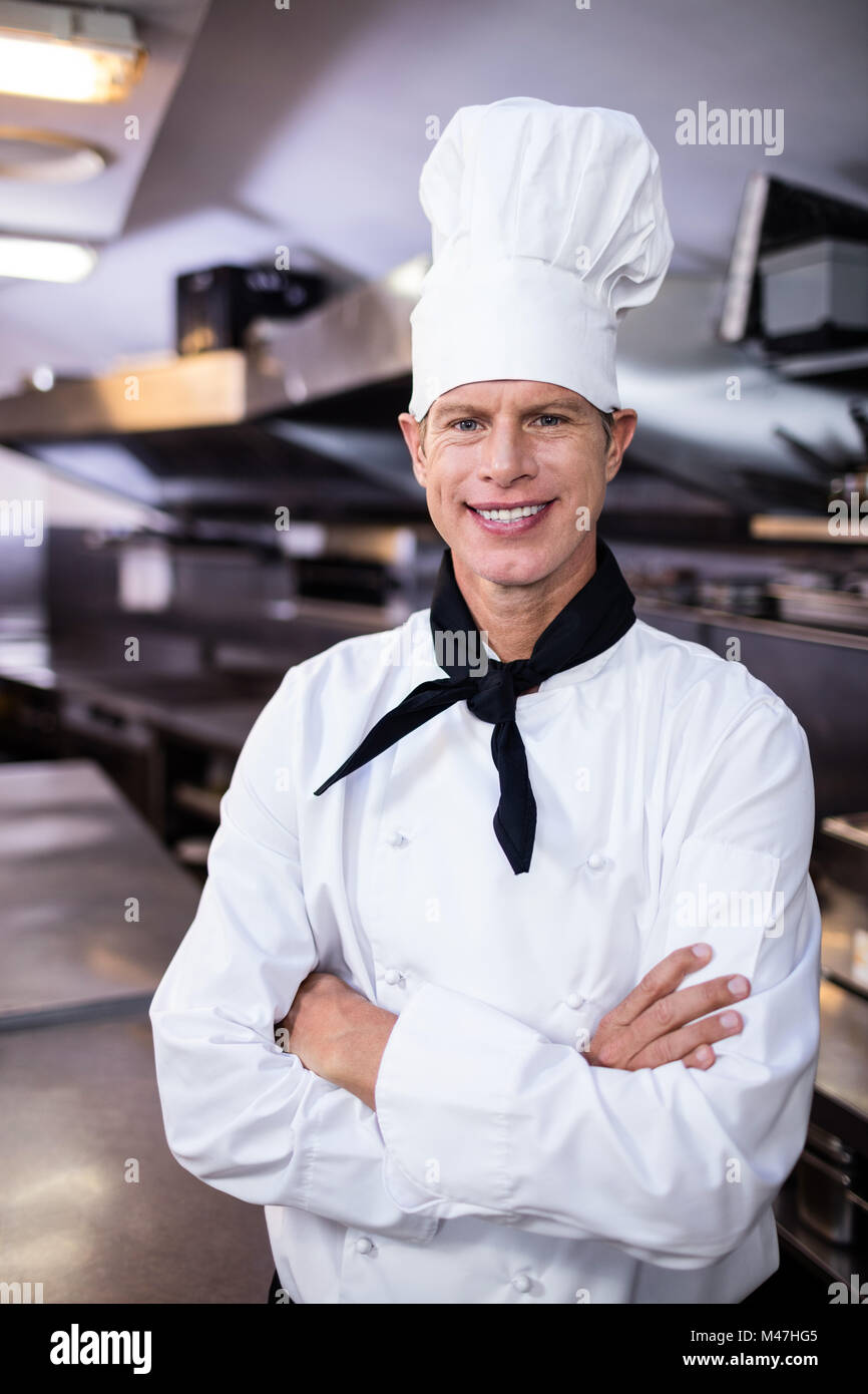 Happy male chef standing with arms crossed in kitchen Stock Photo - Alamy