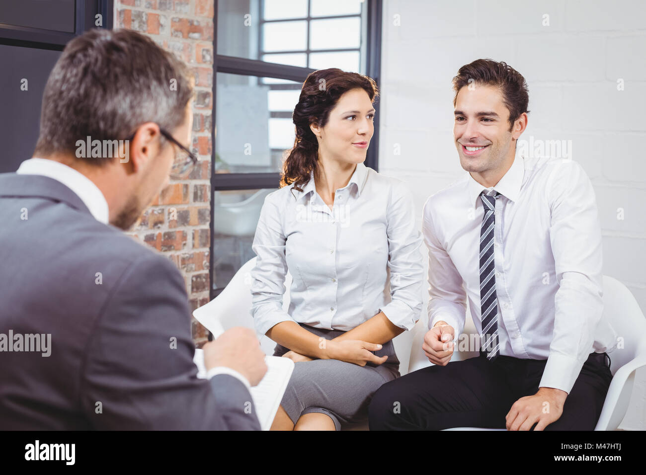 Business professional discussing with smiling clients Stock Photo - Alamy