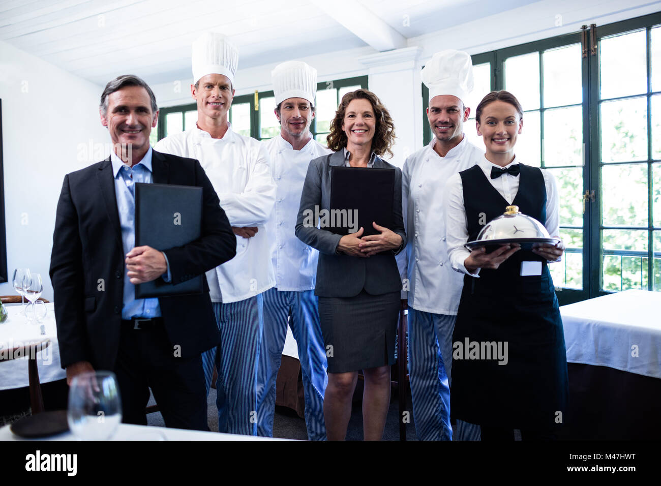 Happy restaurant team standing together in restaurant Stock Photo - Alamy