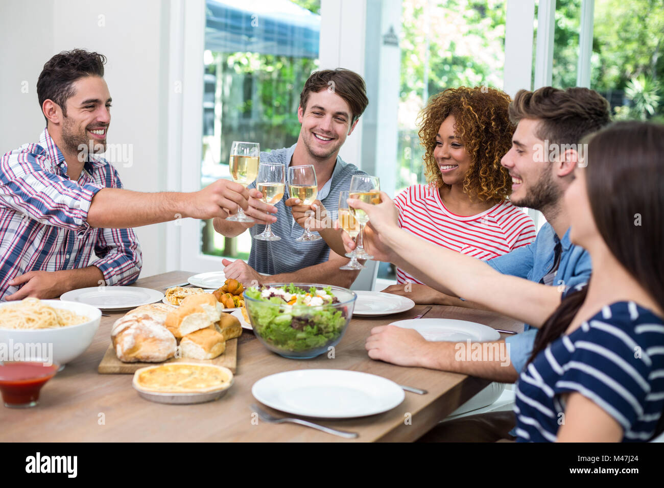 Young friends toasting wine hi-res stock photography and images - Alamy