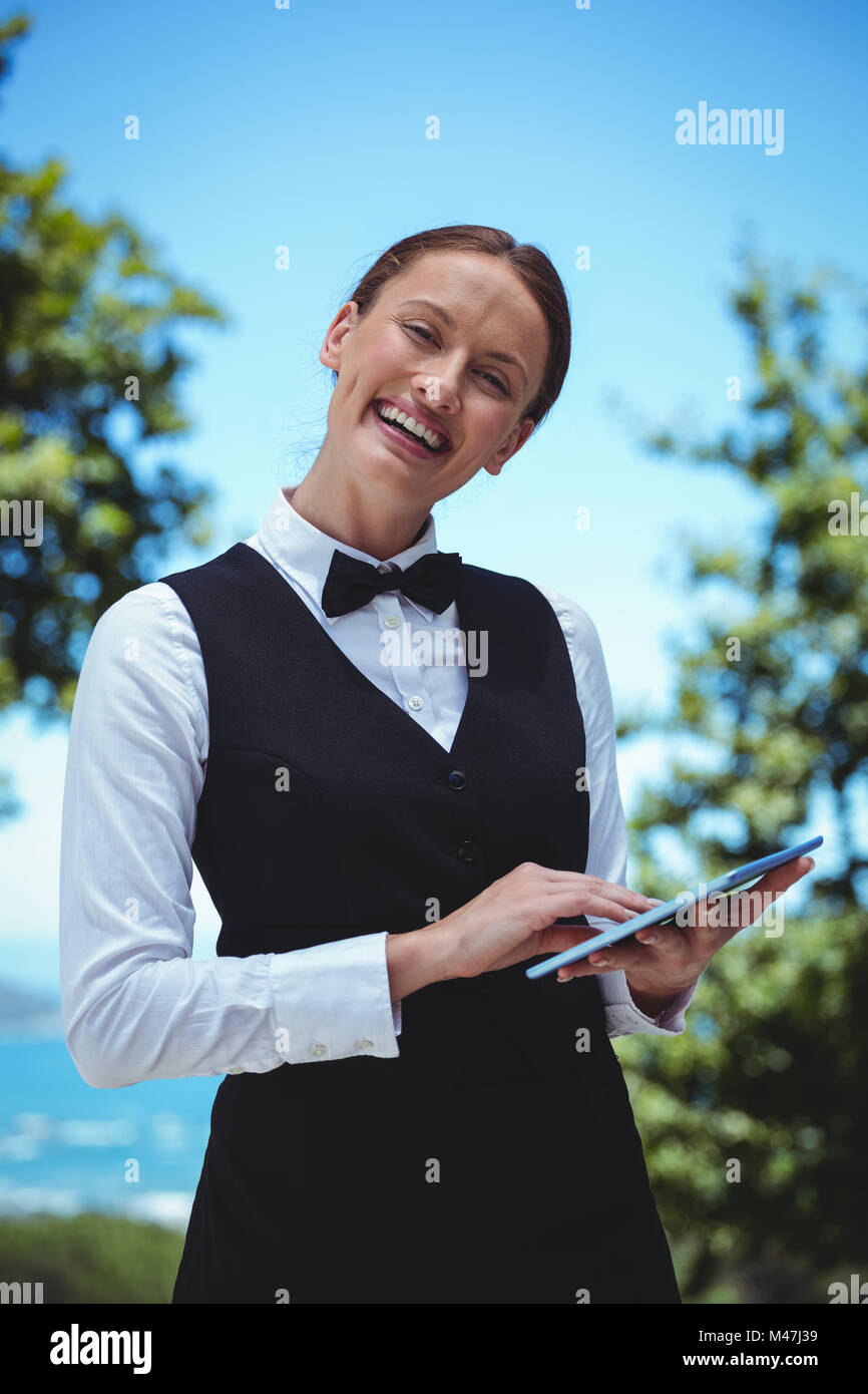 Smiling waitress taking an order with a tablet Stock Photo - Alamy