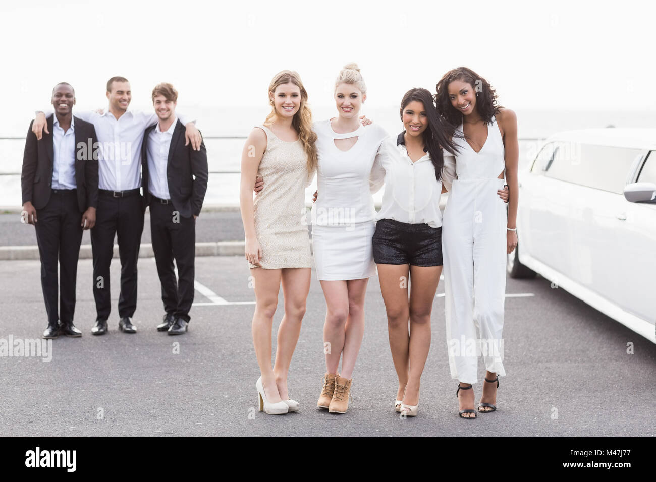 Well dressed people posing next to a limousine Stock Photo - Alamy