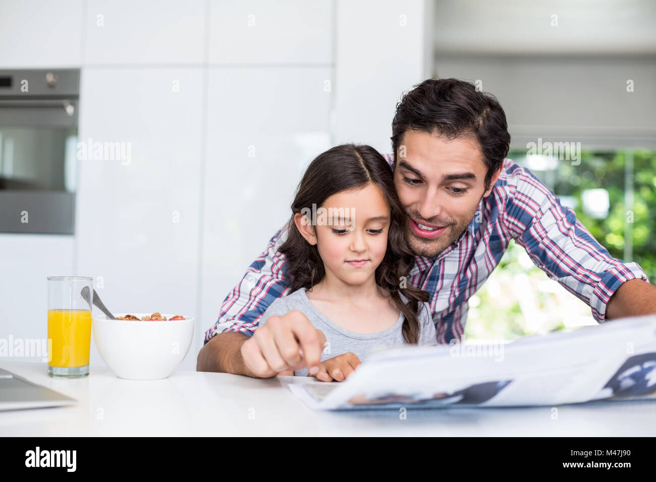 Father and daughter reading newspaper at home Stock Photo - Alamy