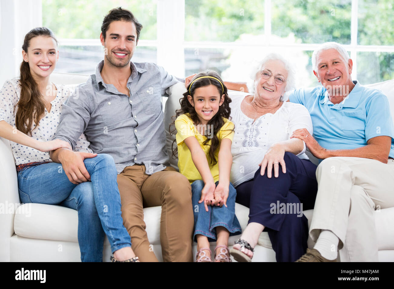 Portrait of smiling family with grandparents on sofa Stock Photo - Alamy