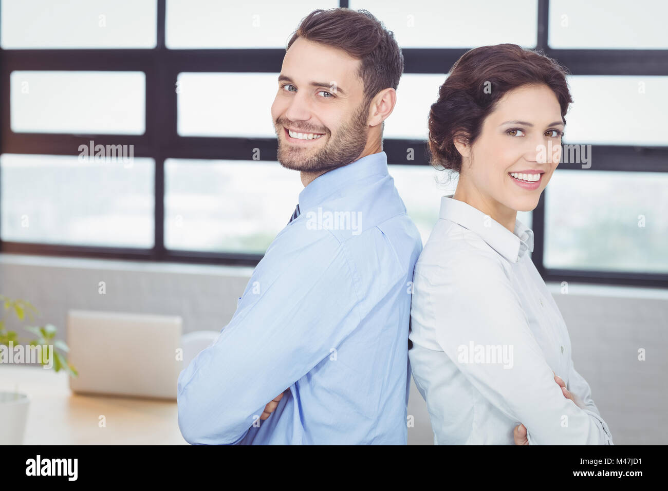 Confident business people standing back to back Stock Photo - Alamy