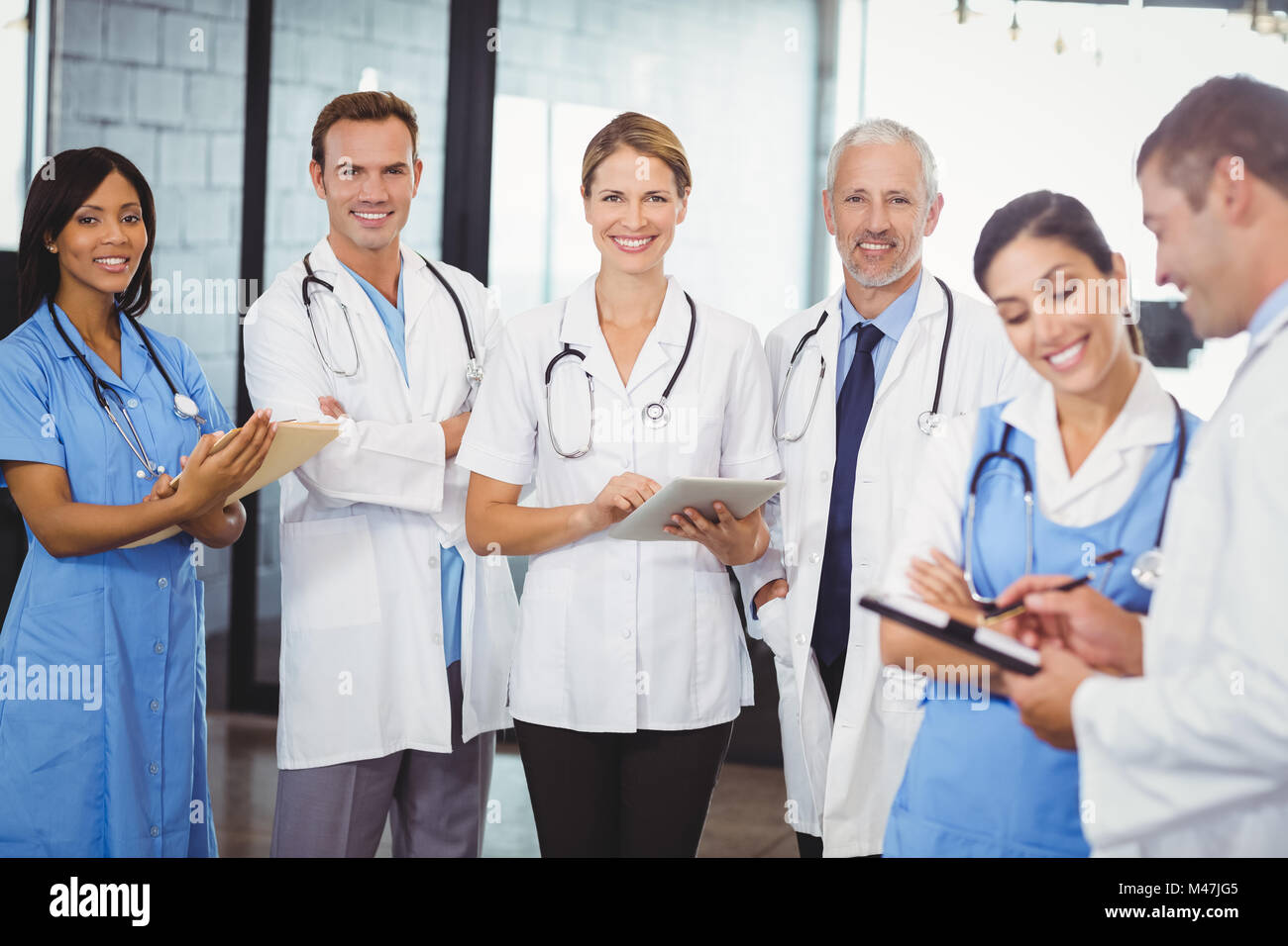 Portrait of medical team standing with file and clipboard Stock Photo ...