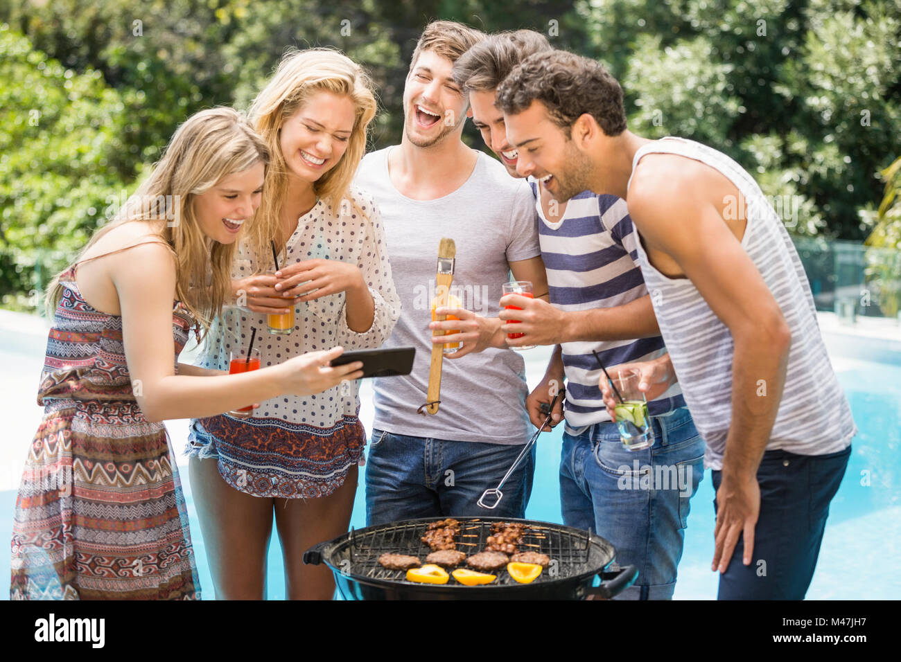 Group of happy friends looking at mobile phone Stock Photo - Alamy