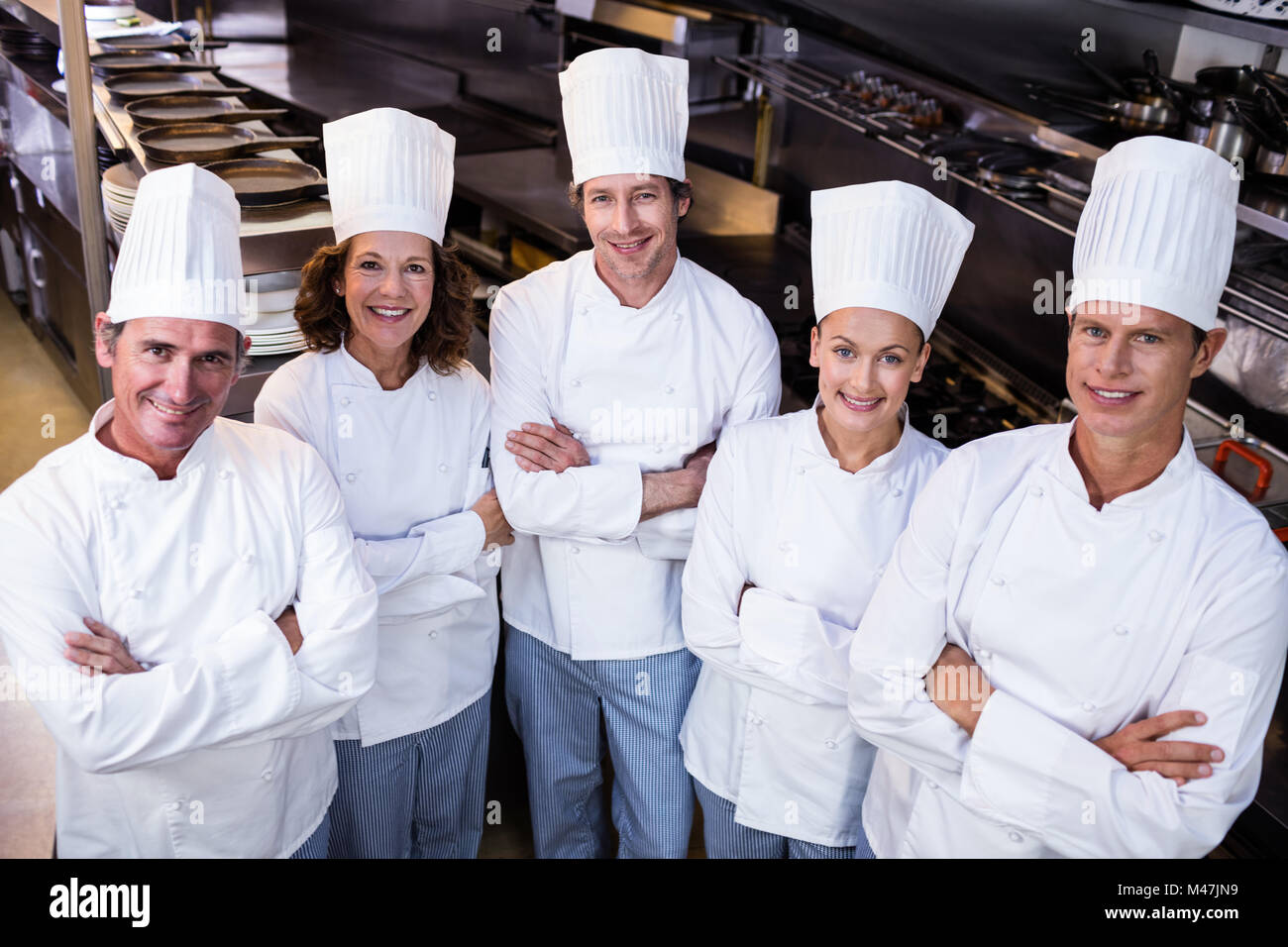 Happy chefs team standing together in commercial kitchen Stock Photo - Alamy