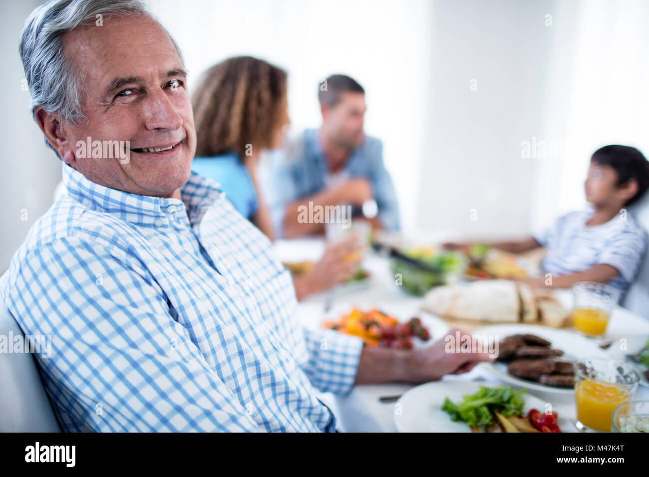 Portrait of senior man sitting at dinning table Stock Photo - Alamy
