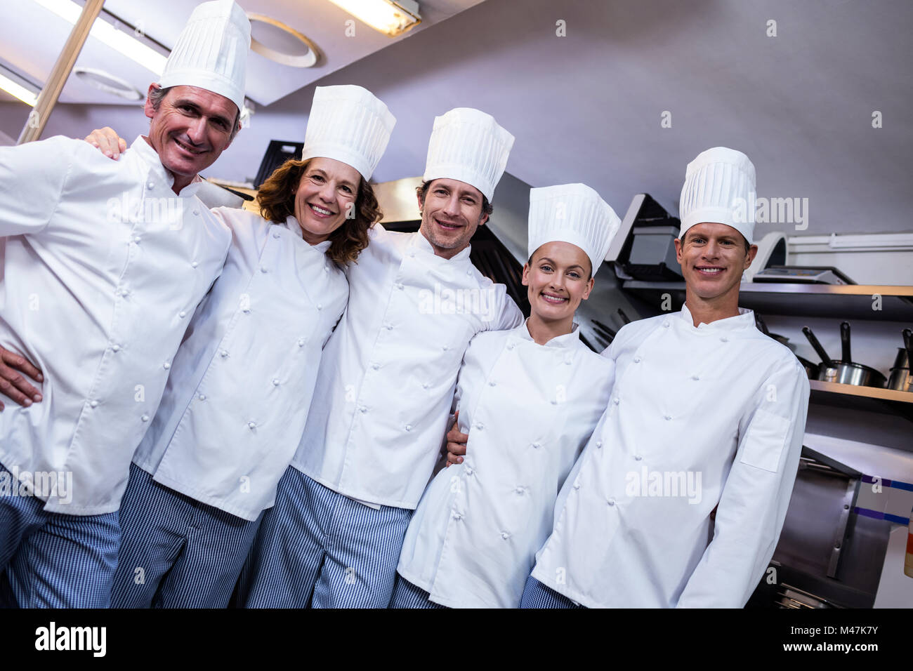 Happy chefs team standing together in commercial kitchen Stock Photo ...