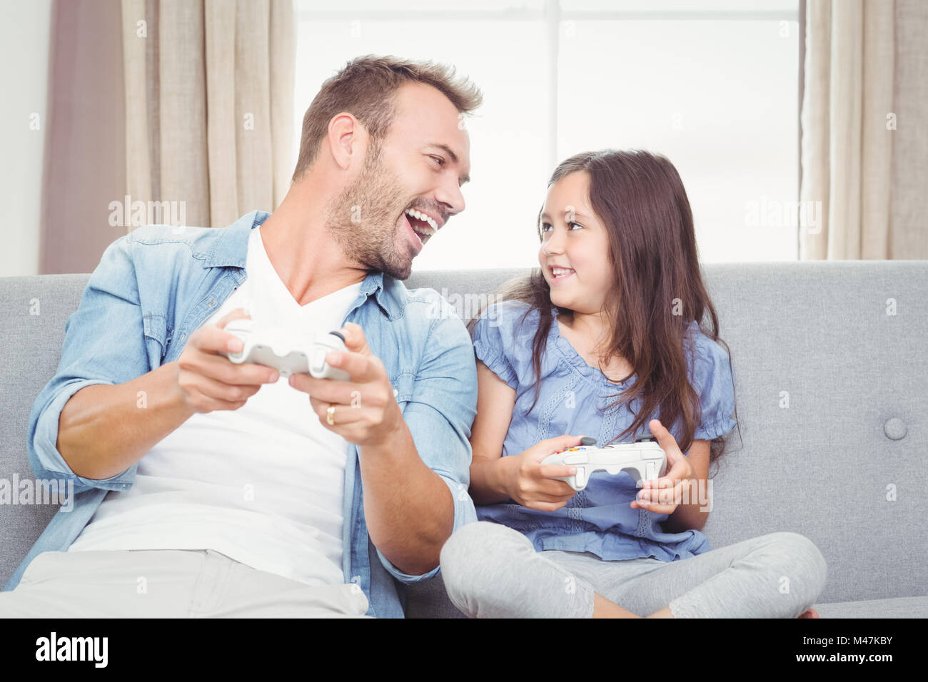 Smiling father and daughter playing video game Stock Photo - Alamy