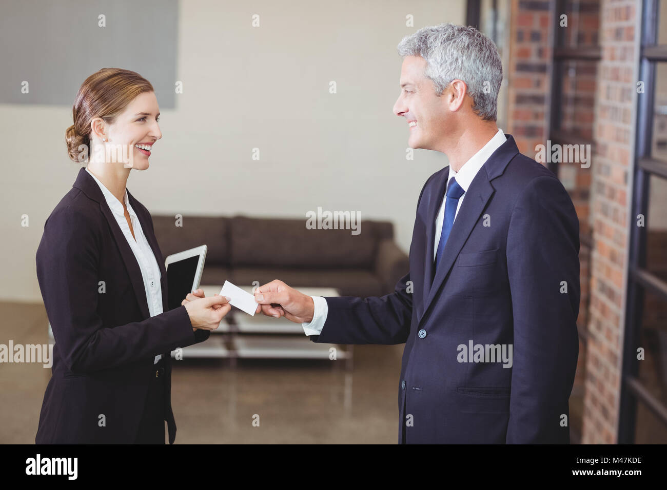 Businesswoman giving business card to client in office Stock Photo - Alamy