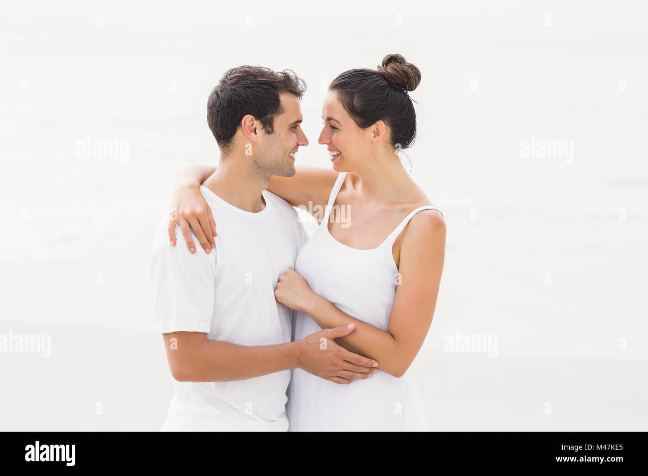 Young couple standing face to face and romancing Stock Photo - Alamy
