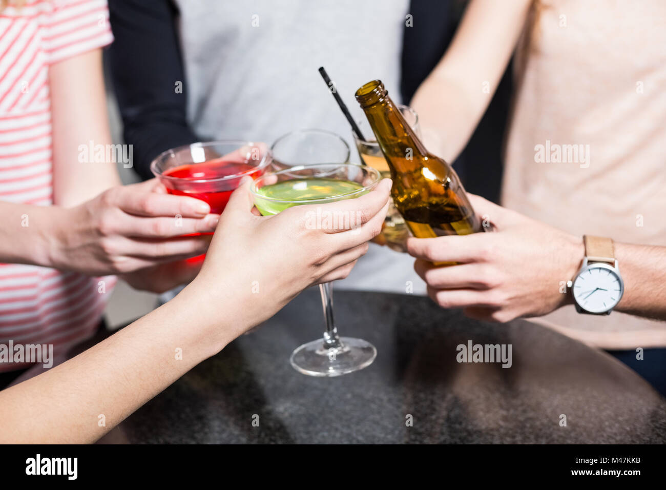 Group of friends toasting with beer and cocktails Stock Photo - Alamy
