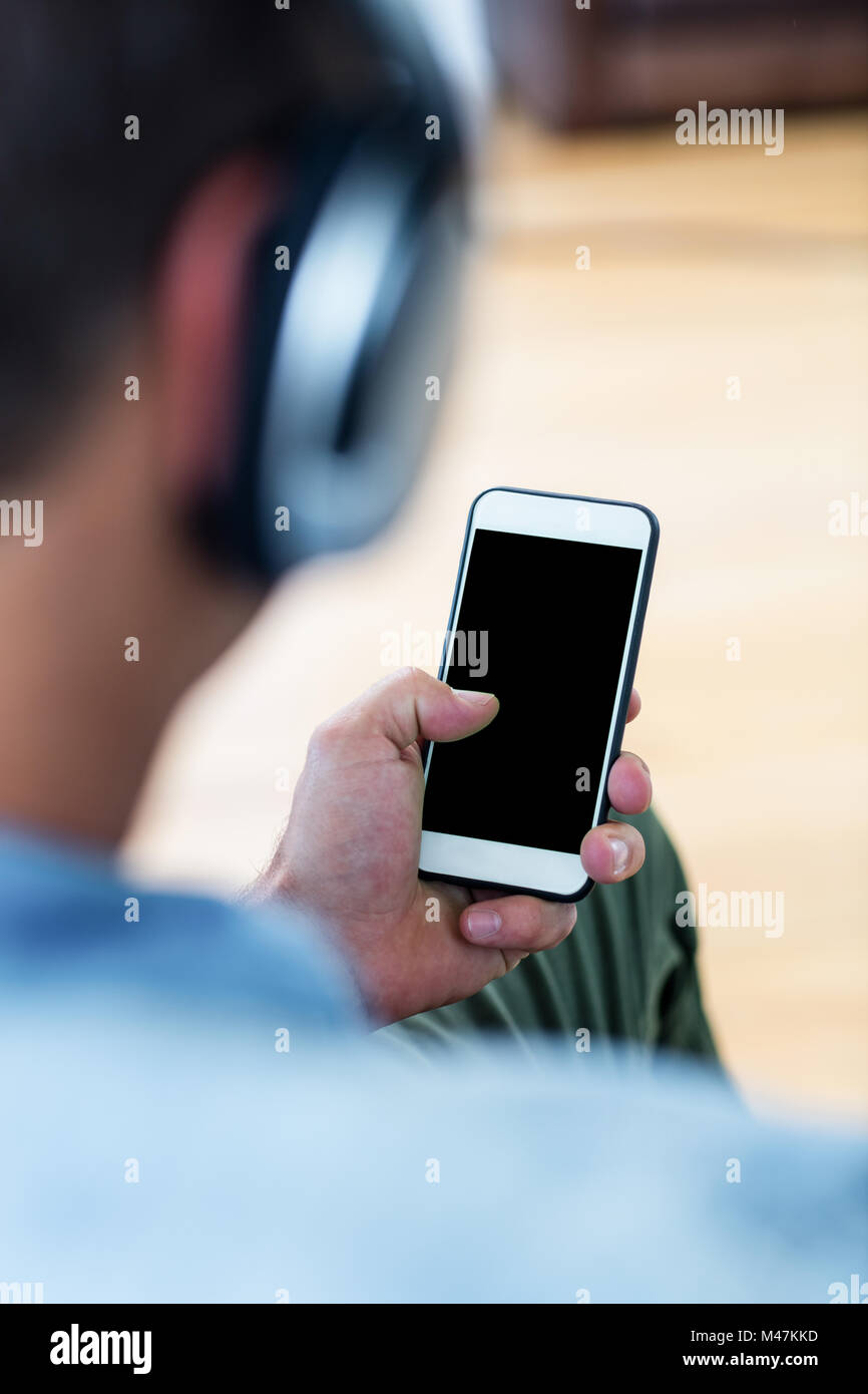 Man listening to music while using mobile phone Stock Photo - Alamy
