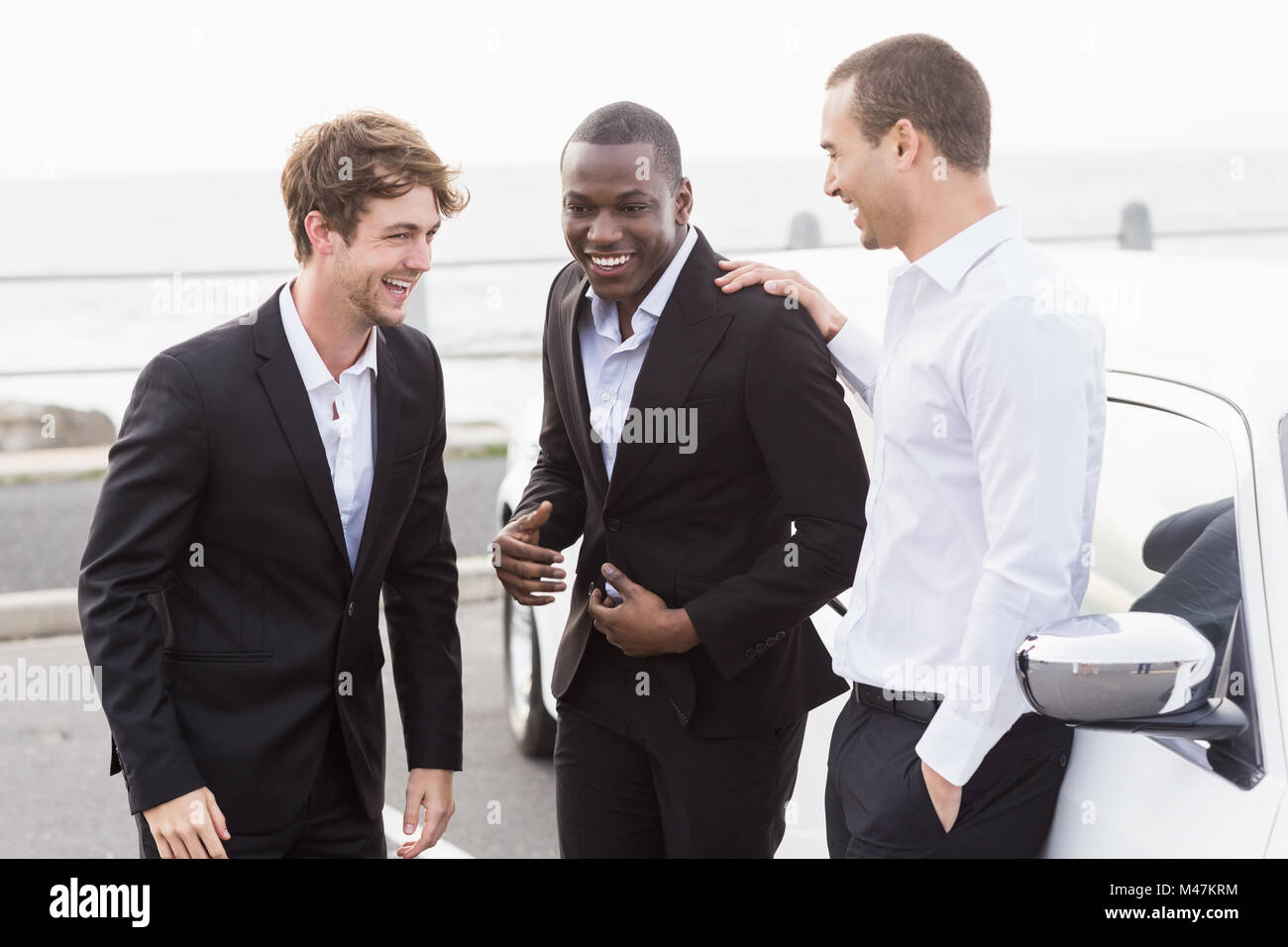 Well dressed people posing next to a limousine Stock Photo - Alamy