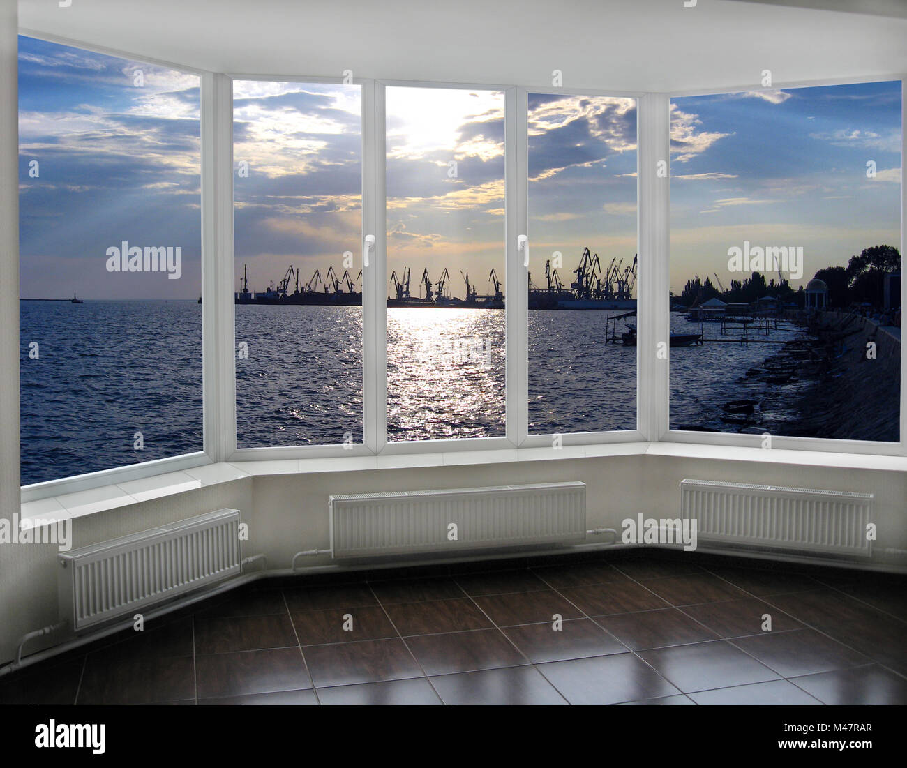 window with view of evening sea port docks and cranes Stock Photo - Alamy