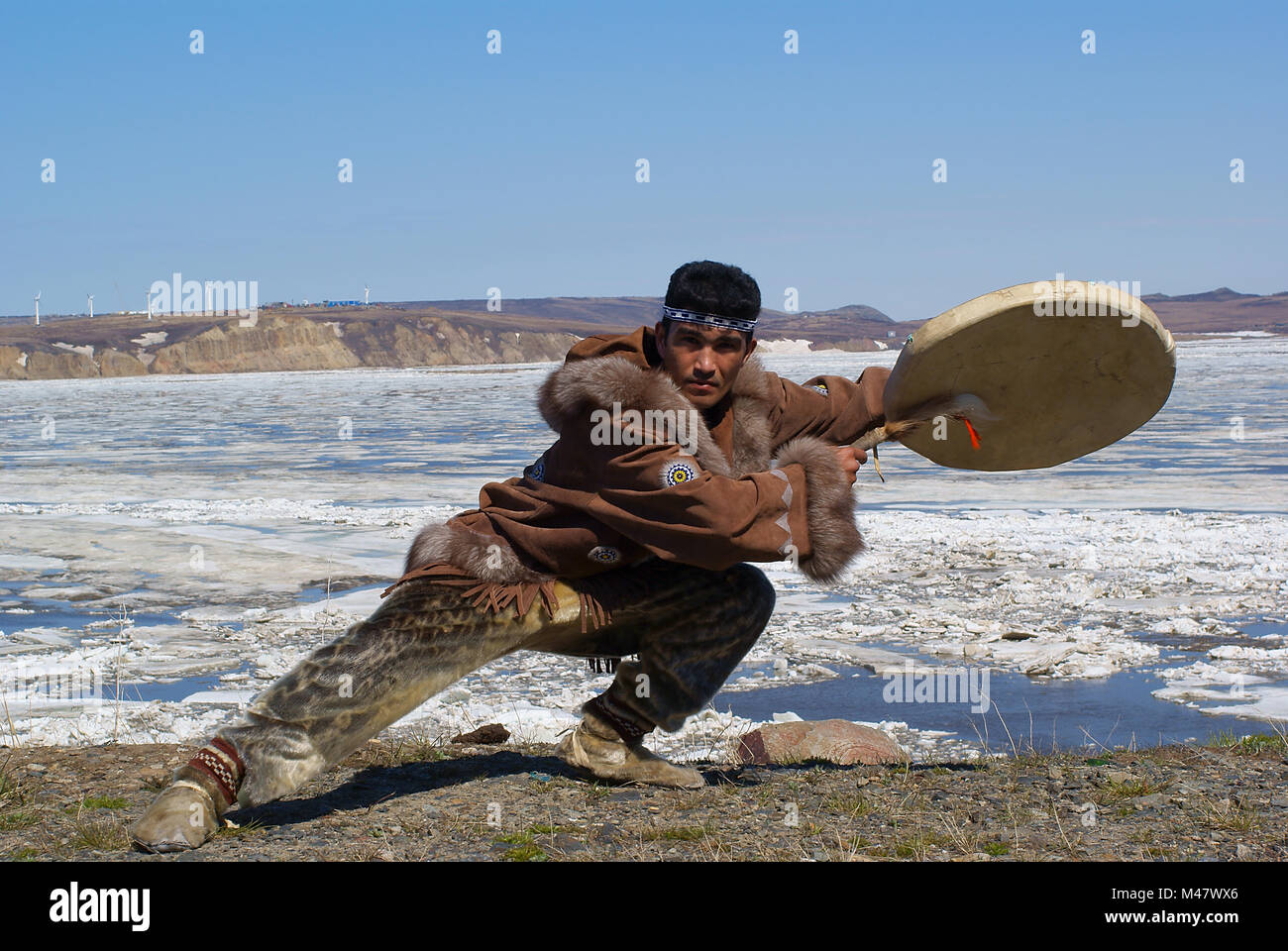 Chukchi man in traditional clothes is dancing a folk dance with ...
