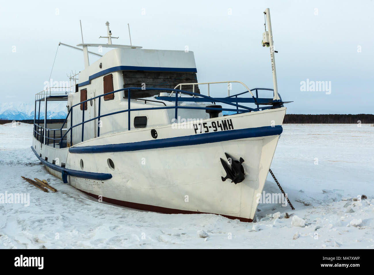 Ship in frozen lake covered with snow in winter evening Stock Photo - Alamy