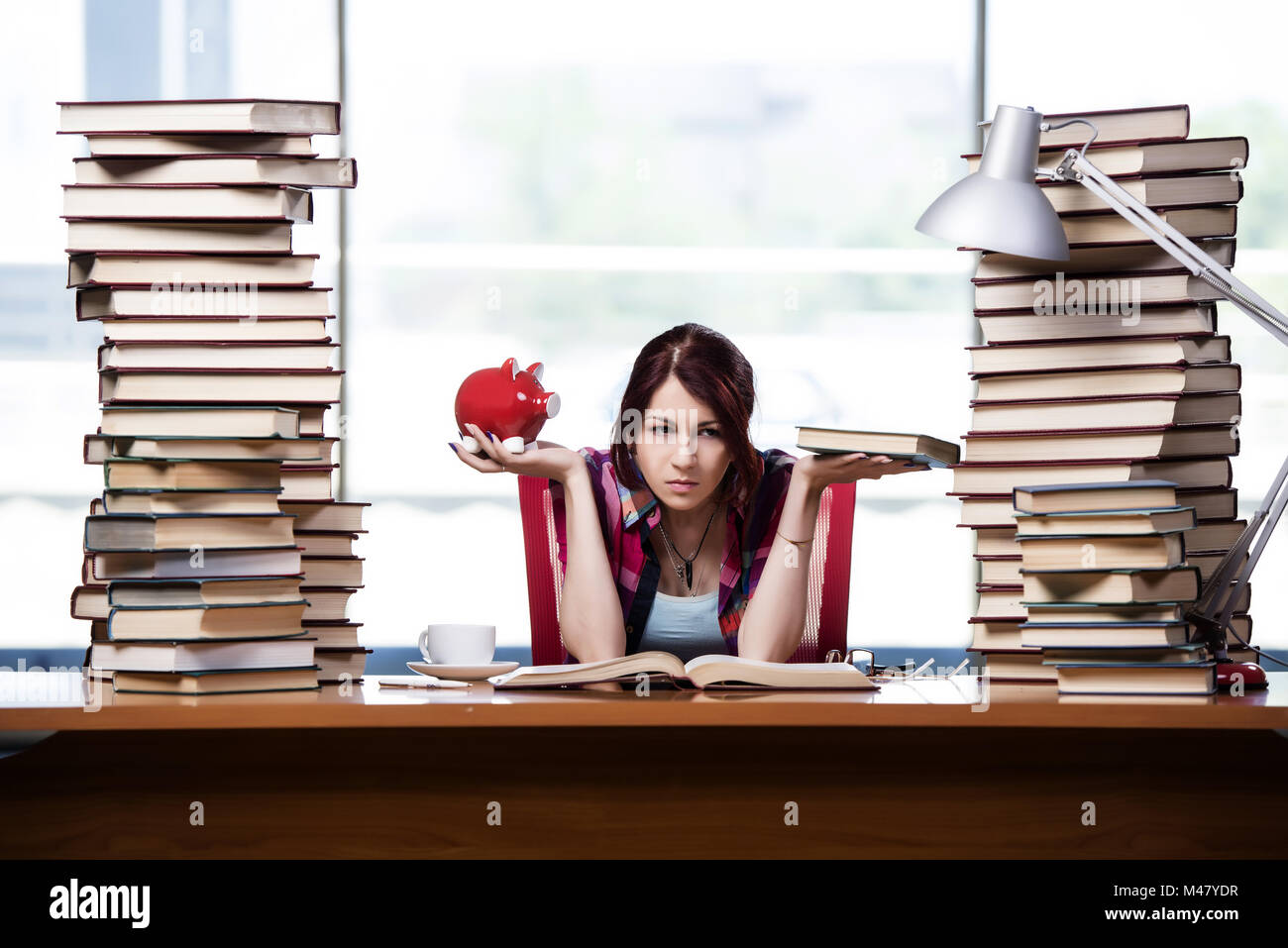 Concept of expensive textbooks with female student Stock Photo - Alamy