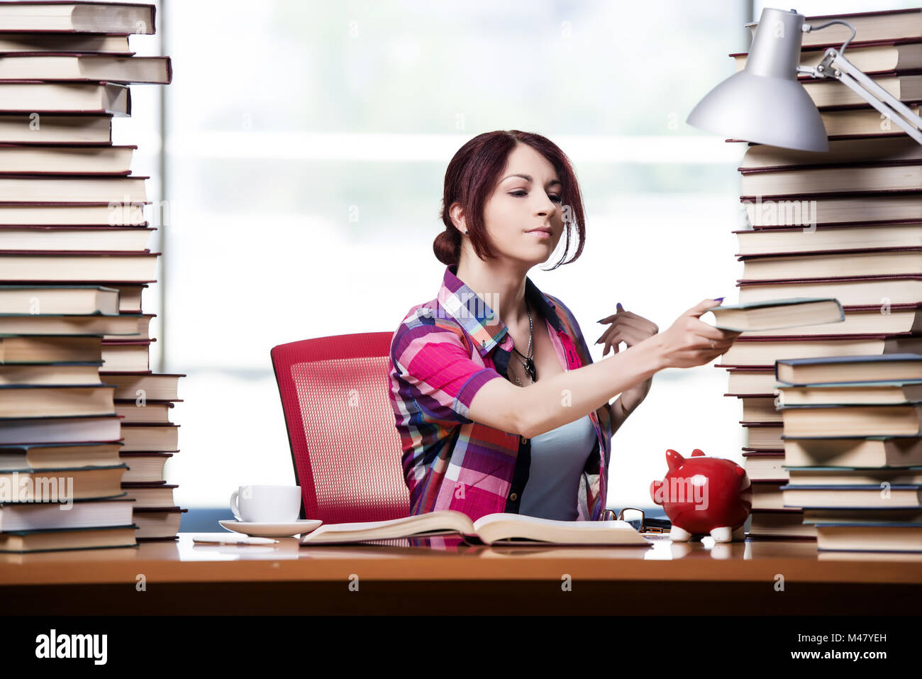 Concept of expensive textbooks with female student Stock Photo - Alamy