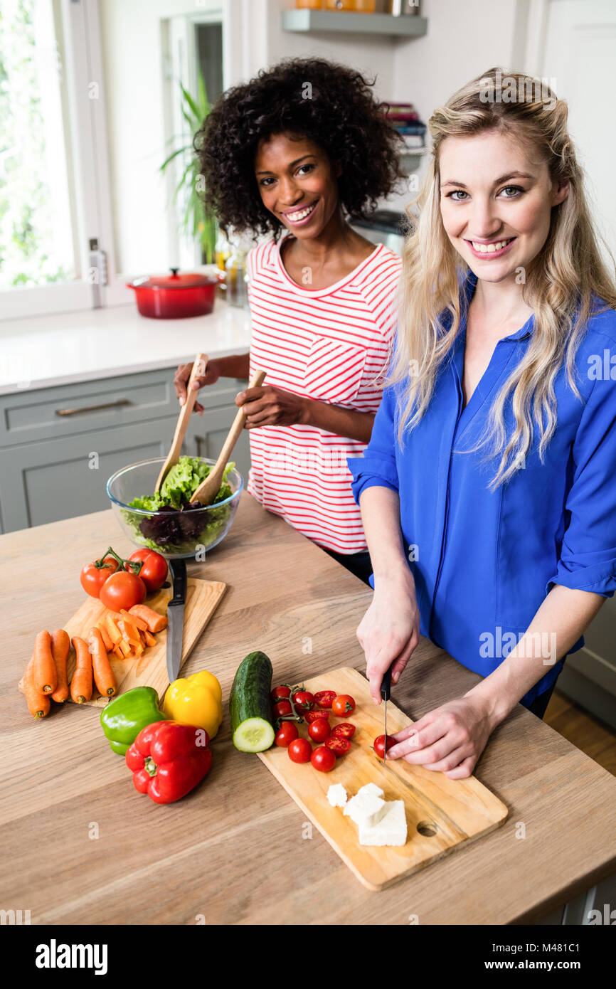 Portrait of cheerful female friends preparing food Stock Photo - Alamy