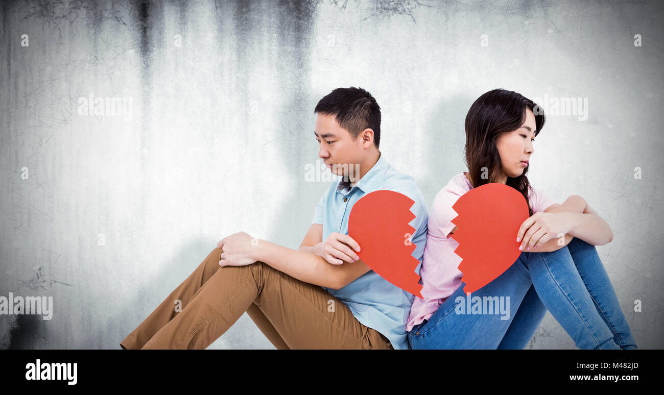 Composite image of sad couple holding broken heart pieces Stock Photo ...