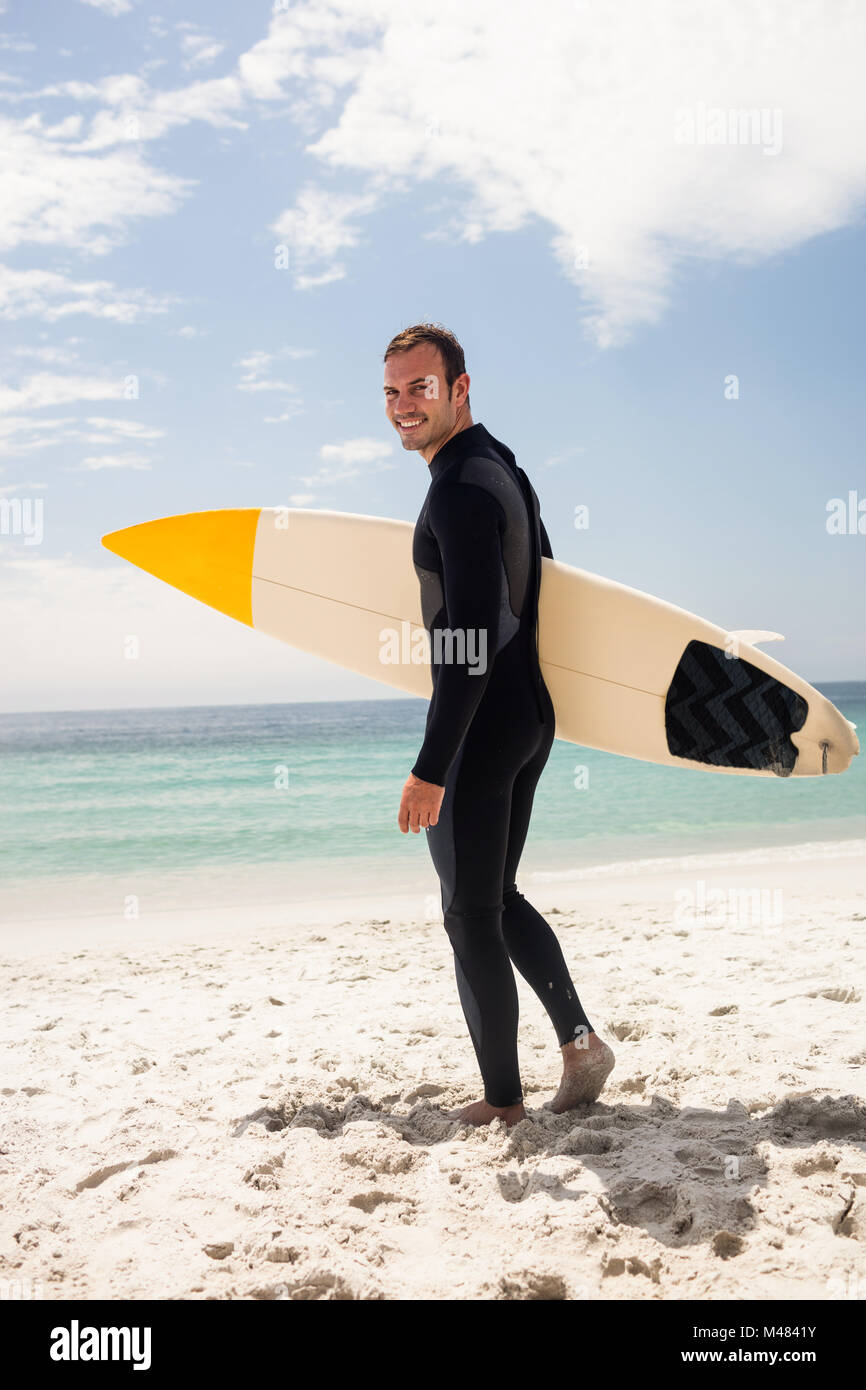 Happy surfer holding a surfboard on the beach Stock Photo - Alamy