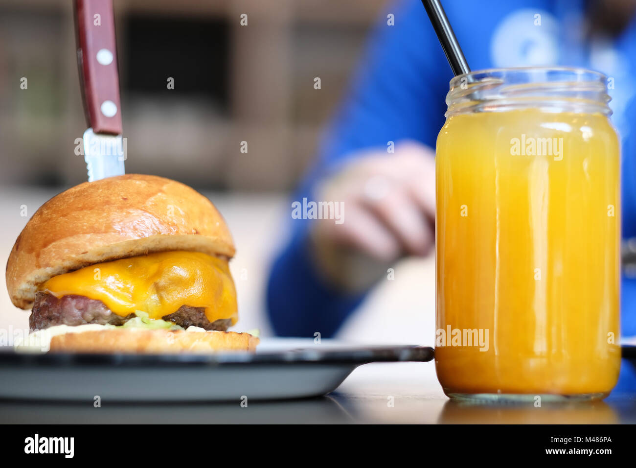 Woman eating cheeseburger Stock Photo - Alamy