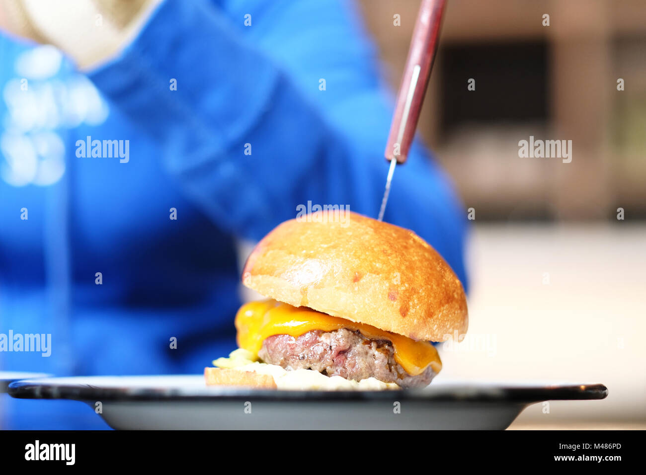 Woman eating cheeseburger Stock Photo - Alamy