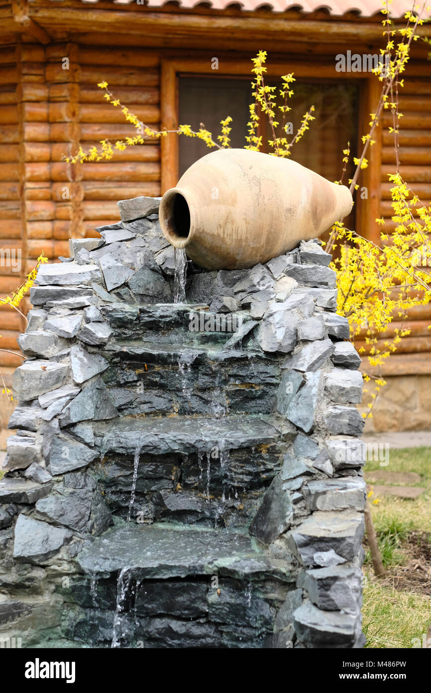Decorative garden waterfall with stone jar Stock Photo - Alamy