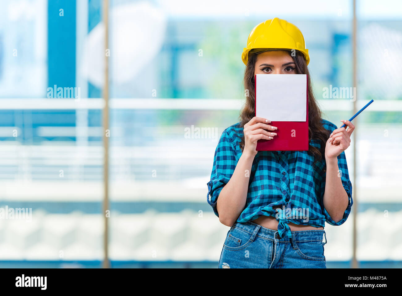 Woman builder taking notes at construction site Stock Photo - Alamy