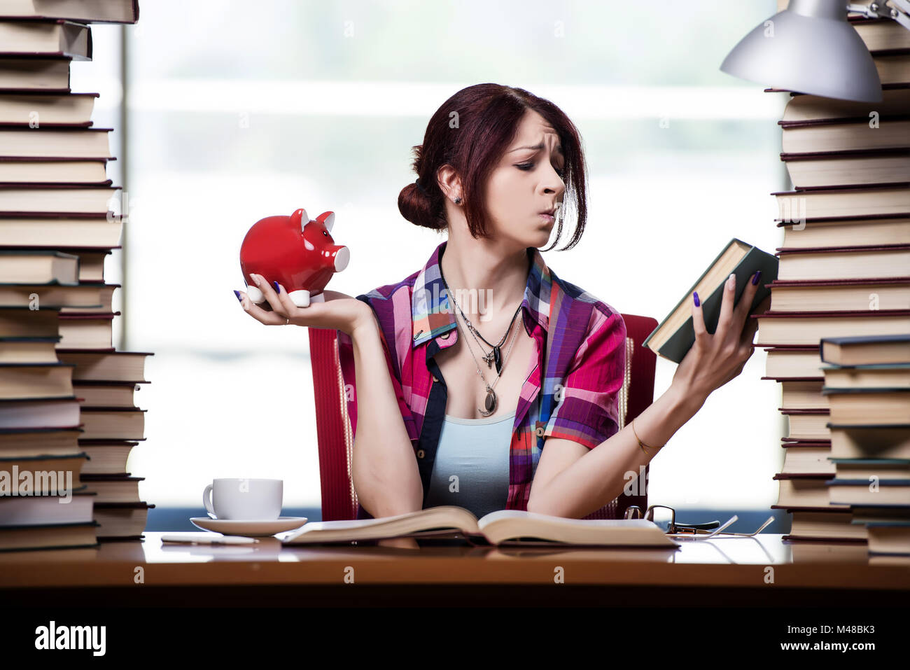 Concept of expensive textbooks with female student Stock Photo - Alamy