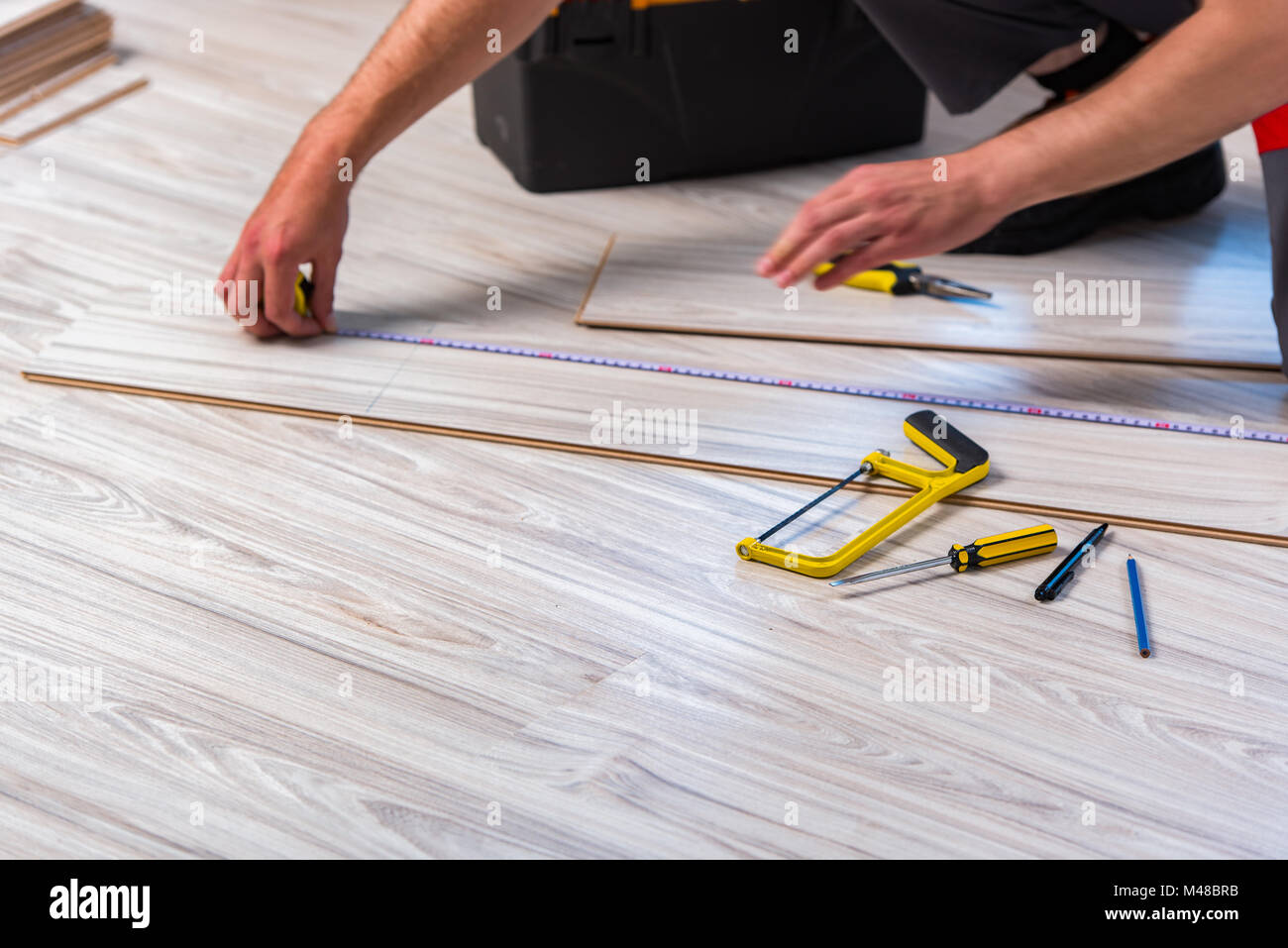 Man laying laminate flooring in construction concept Stock Photo - Alamy