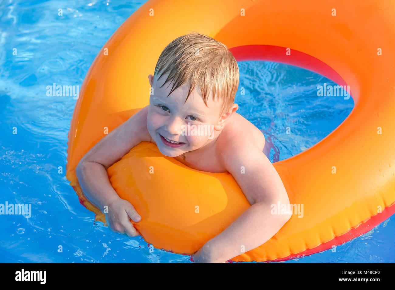 little boy on an inflatable circle in the water Stock Photo - Alamy