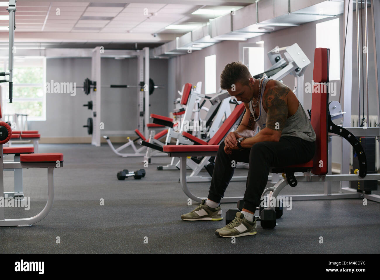 Time for training. Fitness coach looks at clock Stock Photo - Alamy