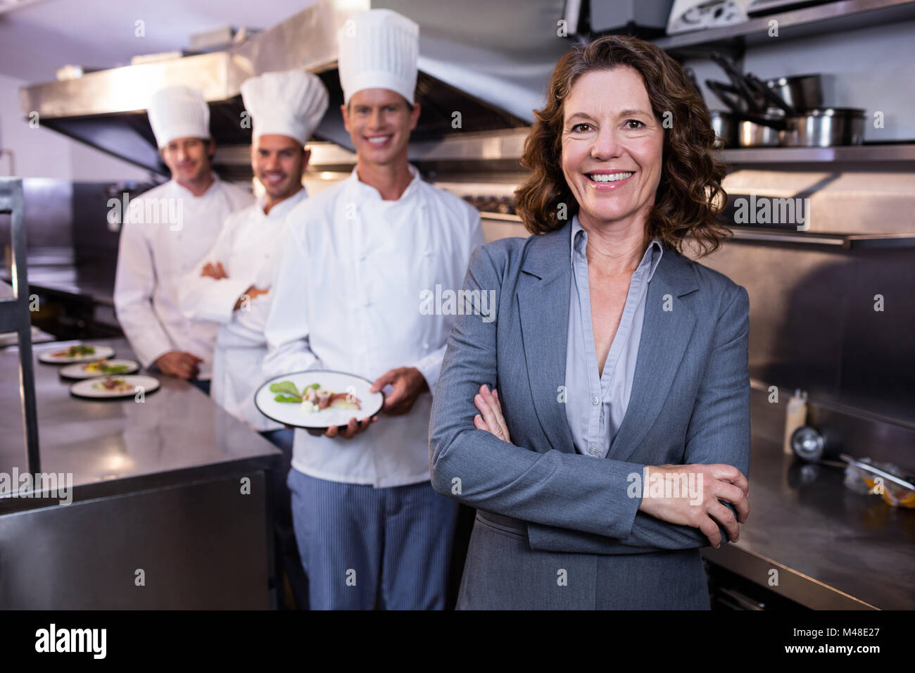 Restaurant manager posing in front of team of chefs Stock Photo - Alamy
