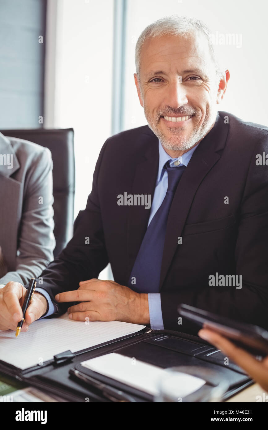 Businessman writing a report in conference room Stock Photo - Alamy