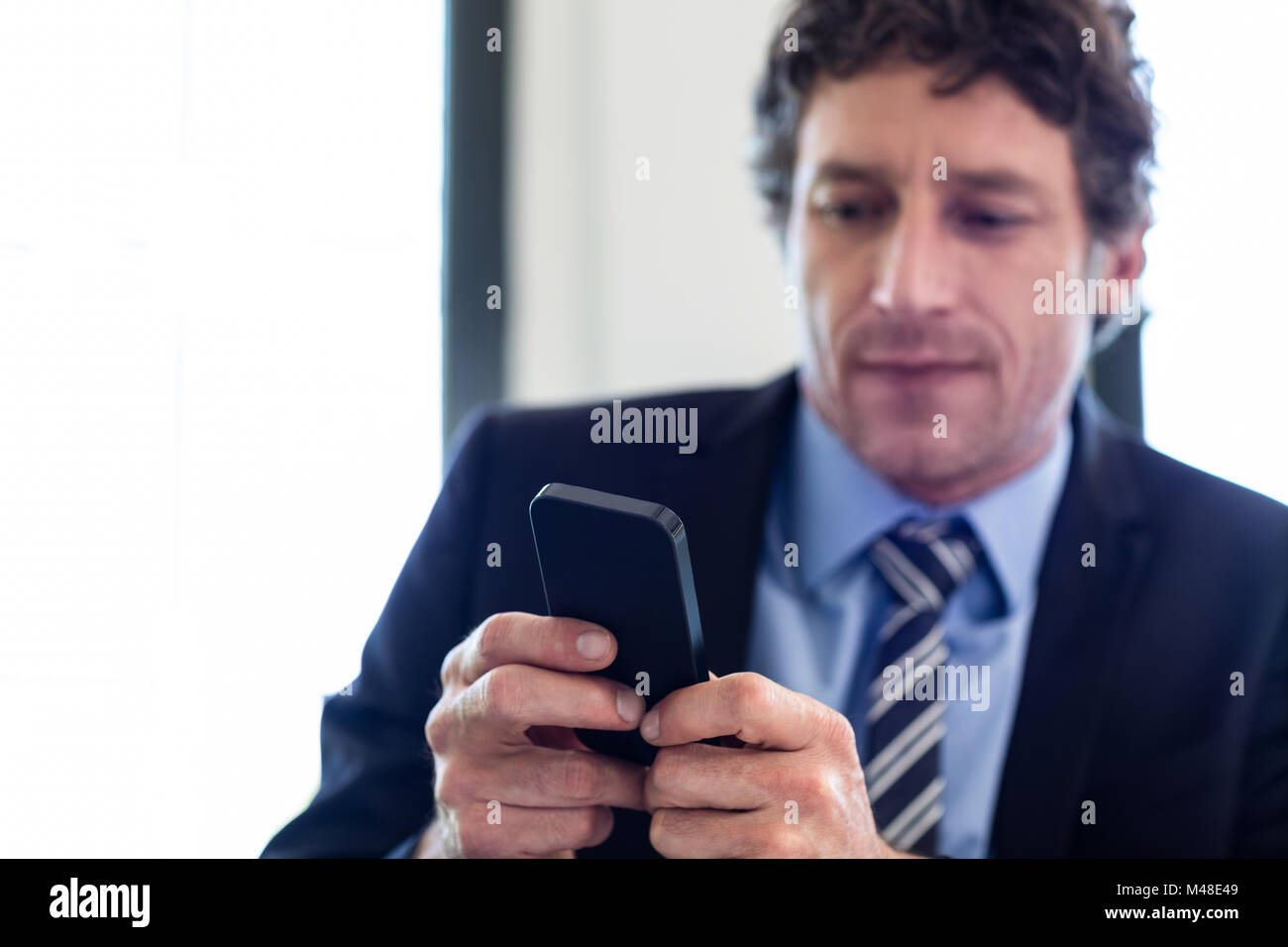 Businessman using his mobile phone at restaurant Stock Photo - Alamy