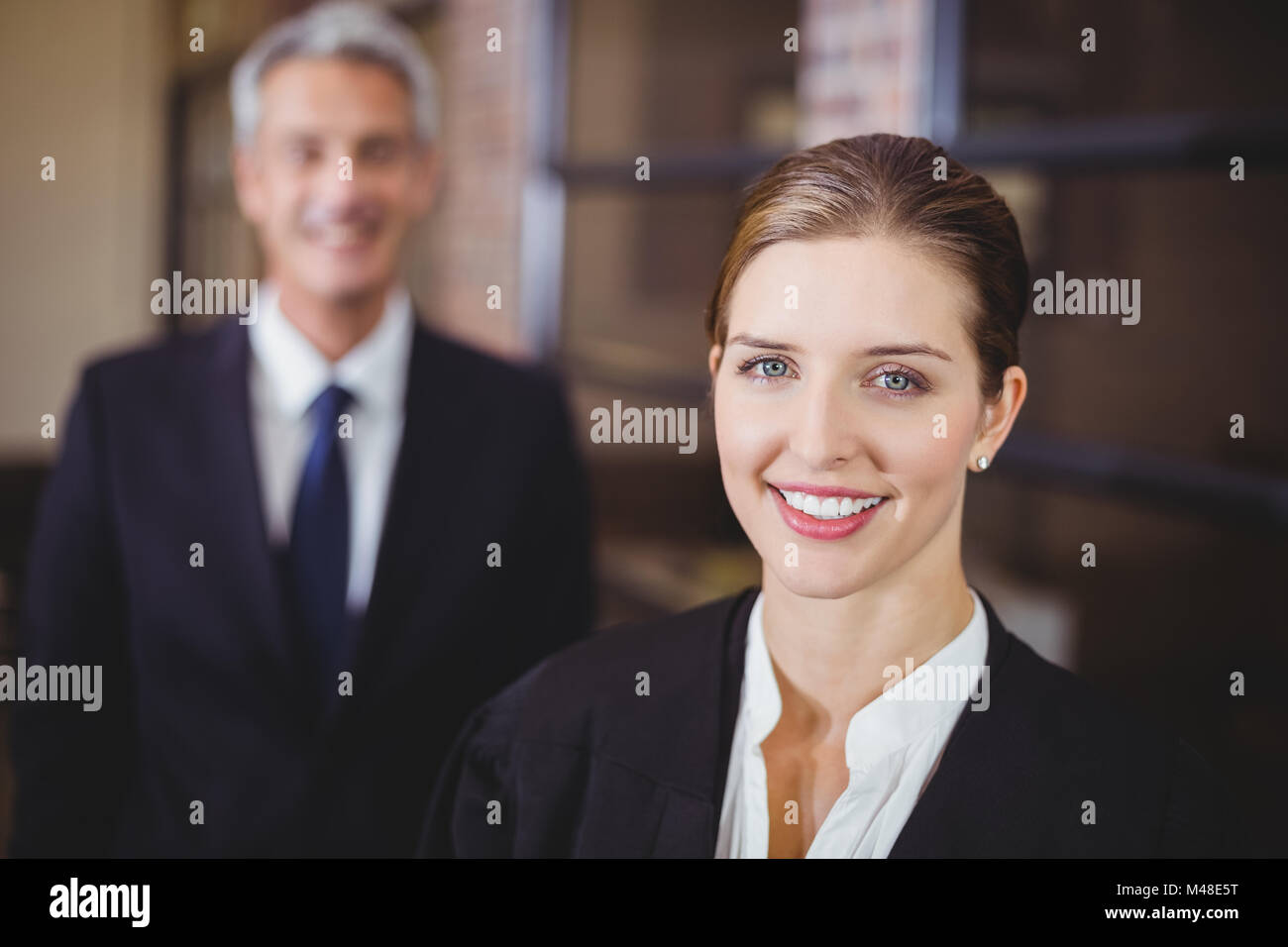 Female lawyer smiling while male colleague in background Stock Photo ...