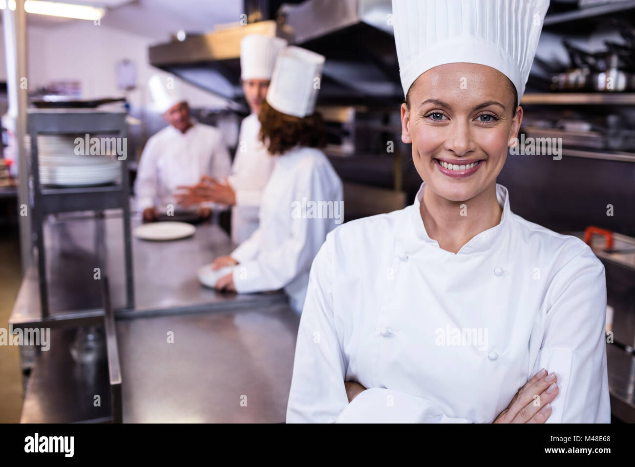 Happy chef standing in commercial kitchen in a restaurant Stock Photo ...