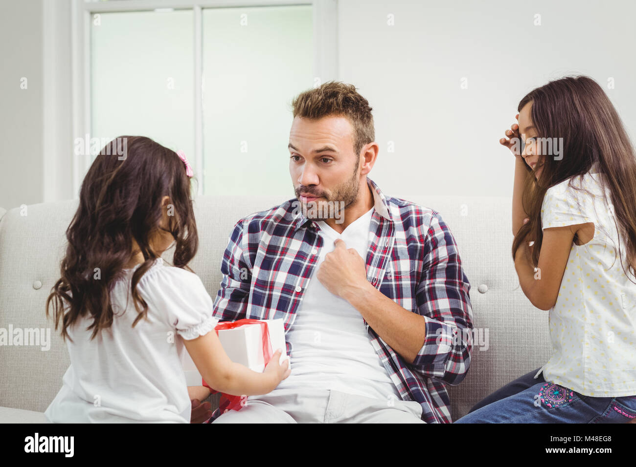 Surprised father looking at daughter with gift Stock Photo - Alamy