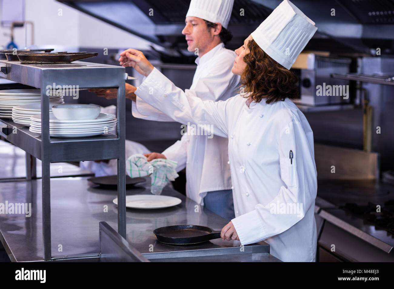 Two chefs working at order station in a kitchen Stock Photo - Alamy