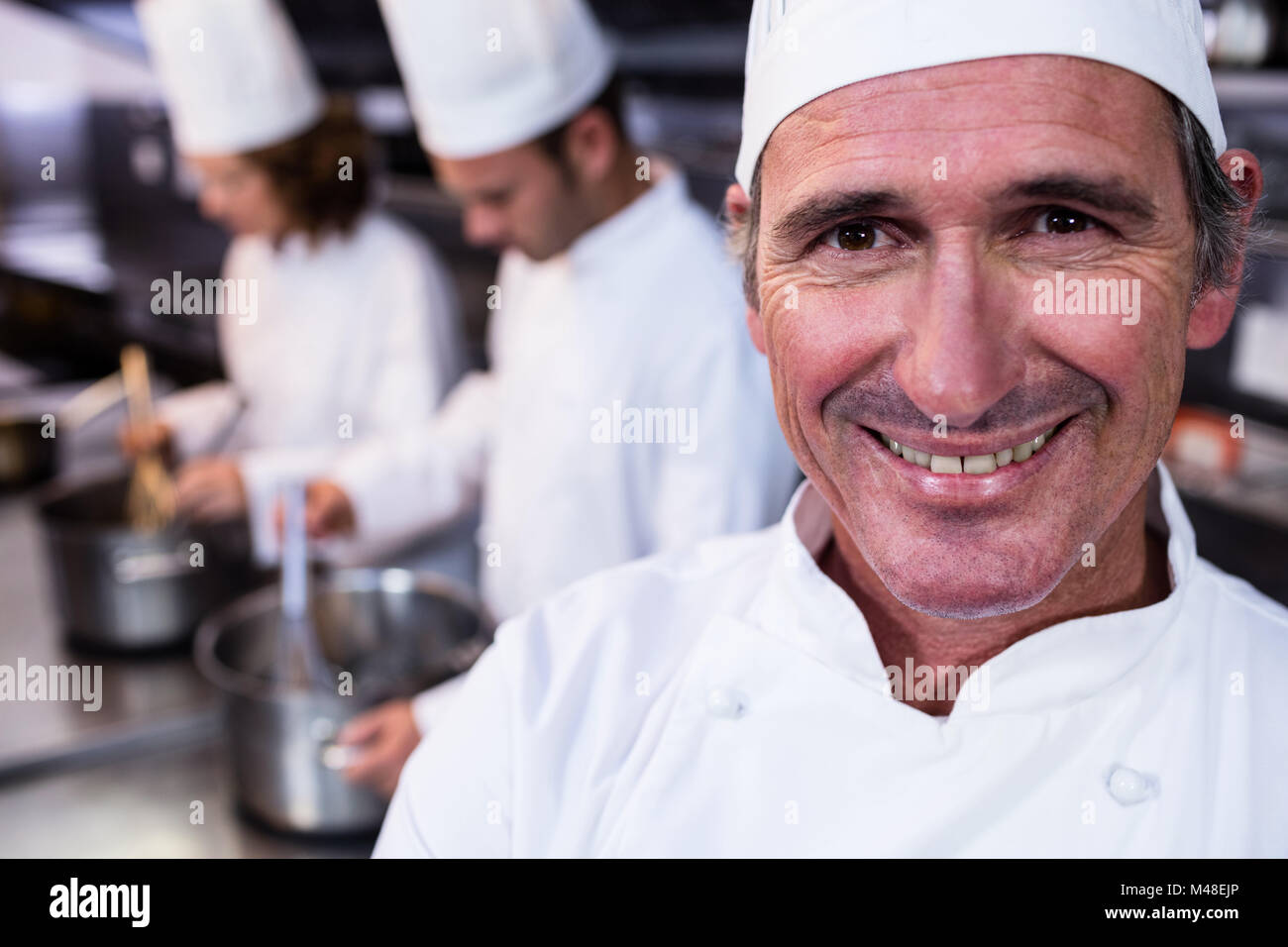 Portrait of smiling chef in commercial kitchen Stock Photo - Alamy
