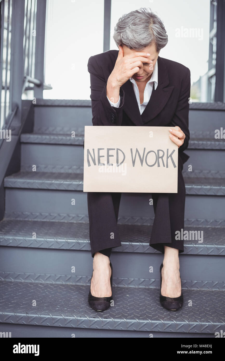 Unemployed businesswoman with need work placard Stock Photo - Alamy