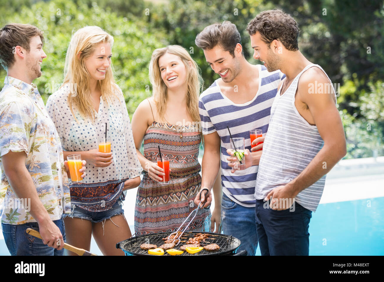 Group of friends preparing barbecue near pool Stock Photo - Alamy